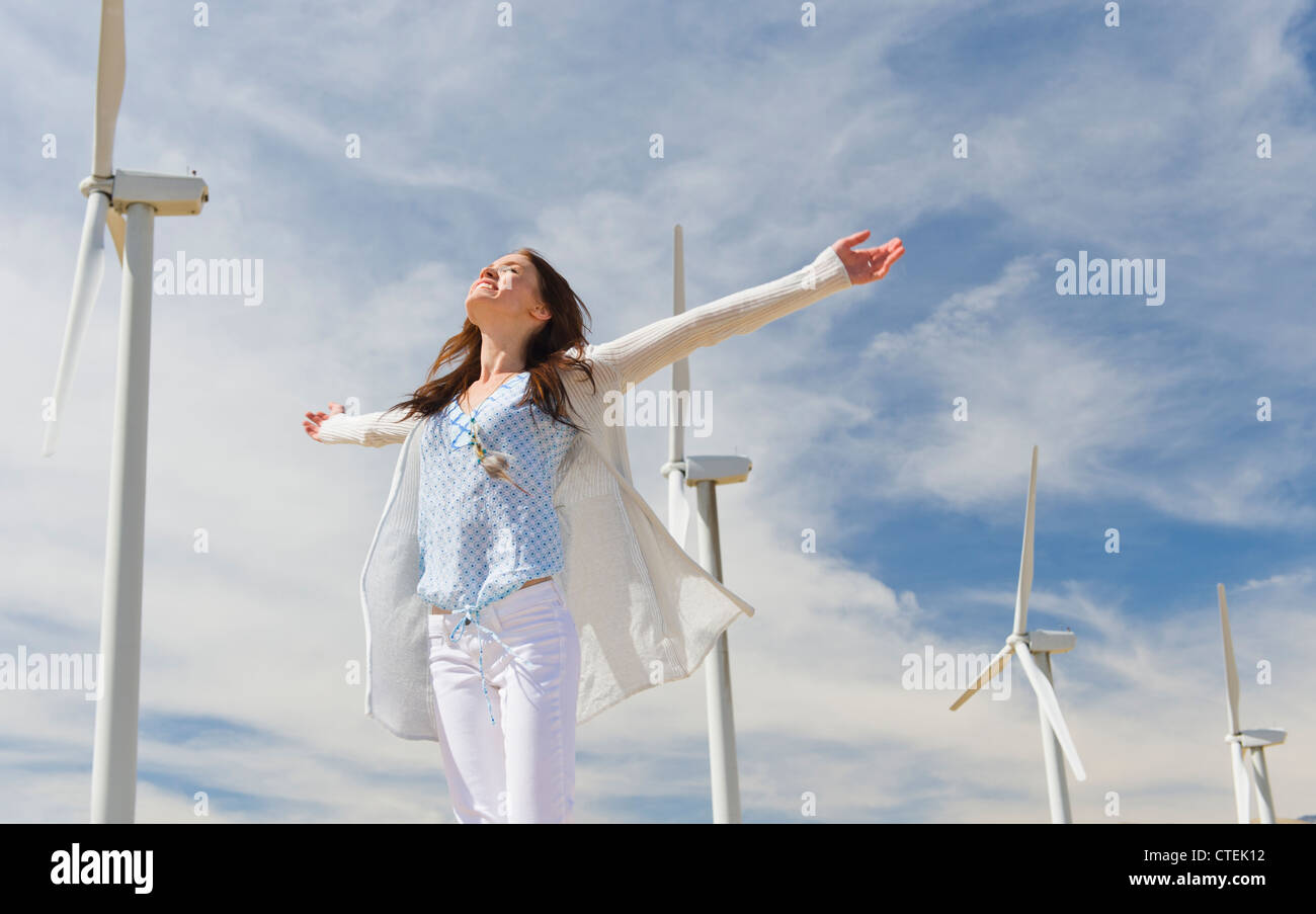 USA, California, Joshua Tree National Park, Young woman at wind farm ...