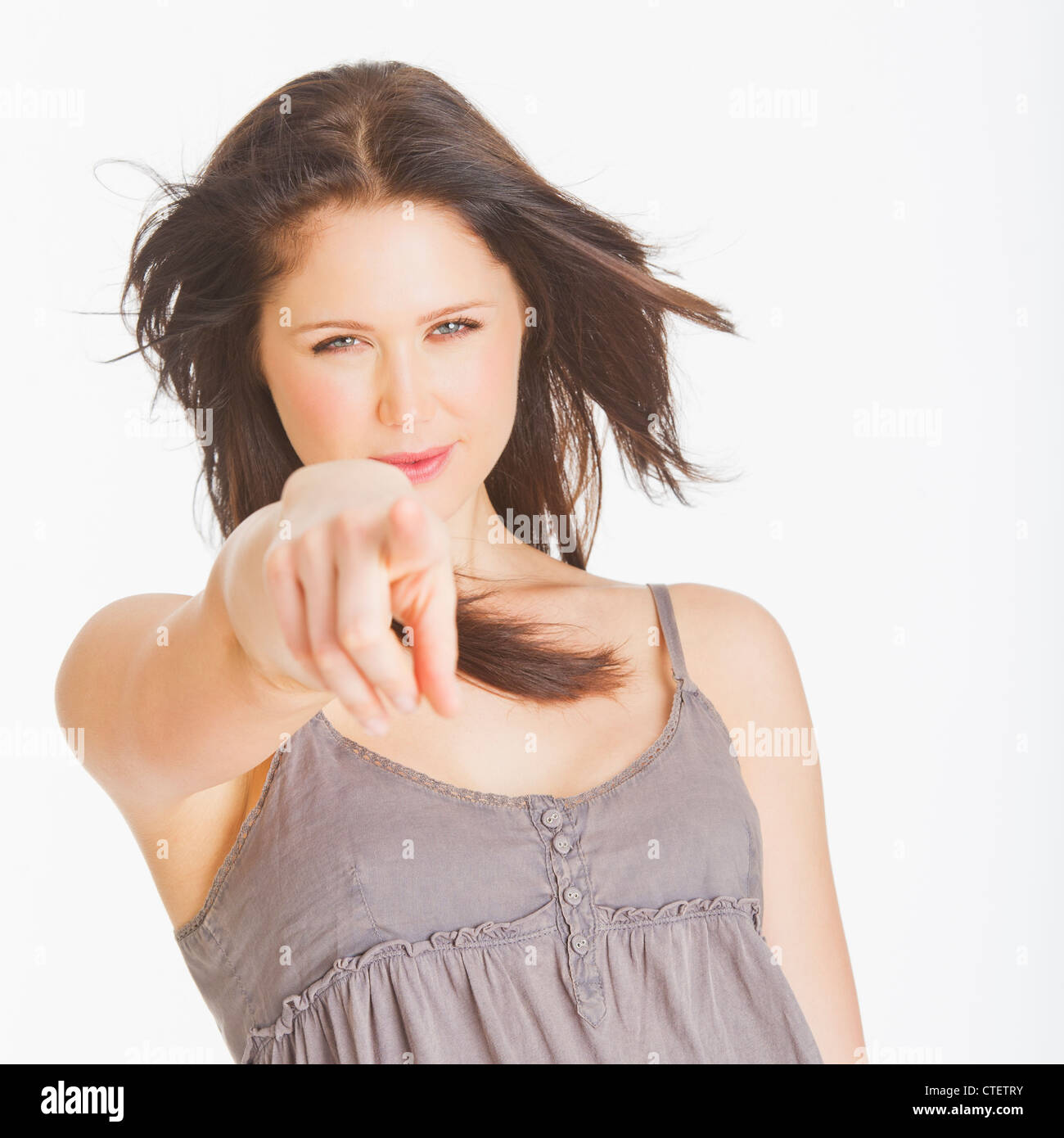 Portrait of young woman pointing with finger, studio shot Stock Photo ...