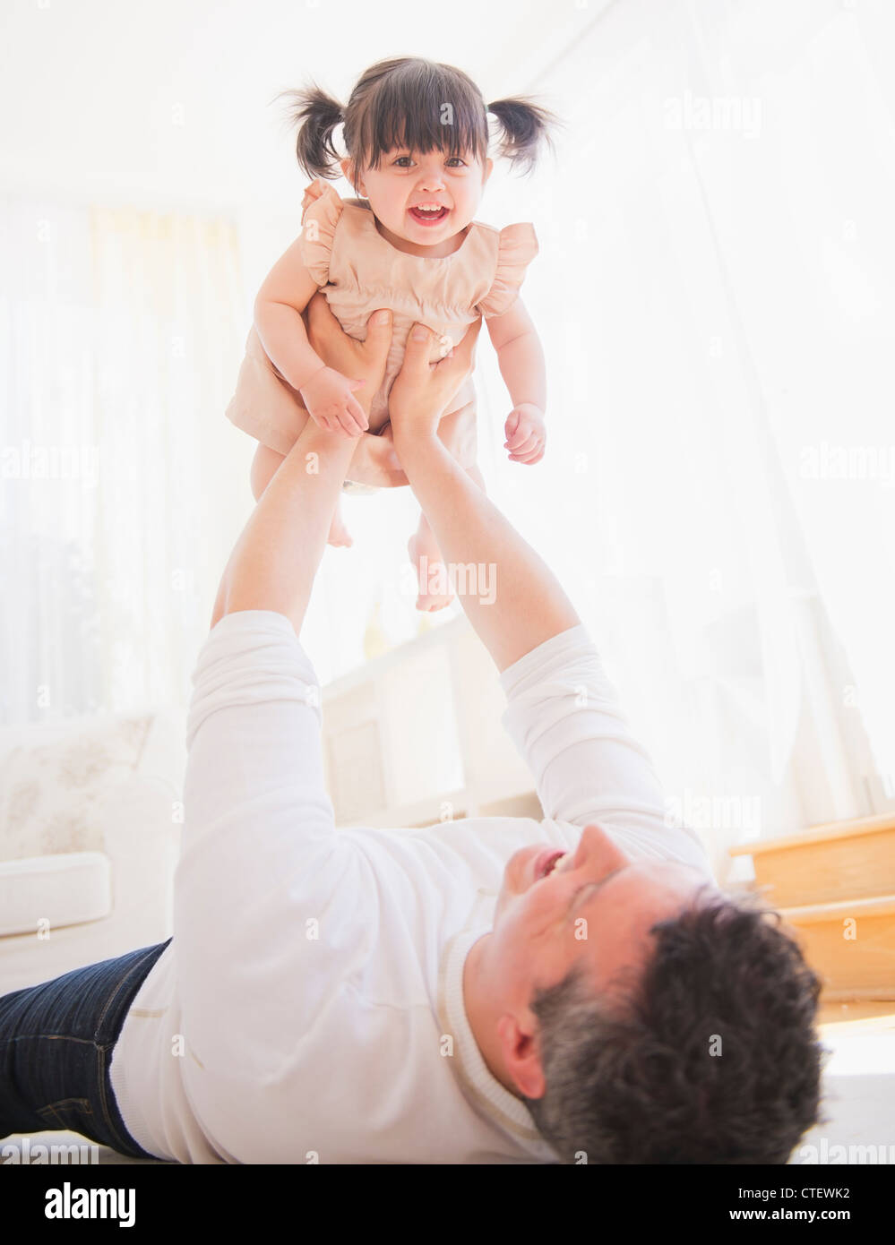 USA, New Jersey, Jersey City, Father lifting baby daughter (12-17 ...