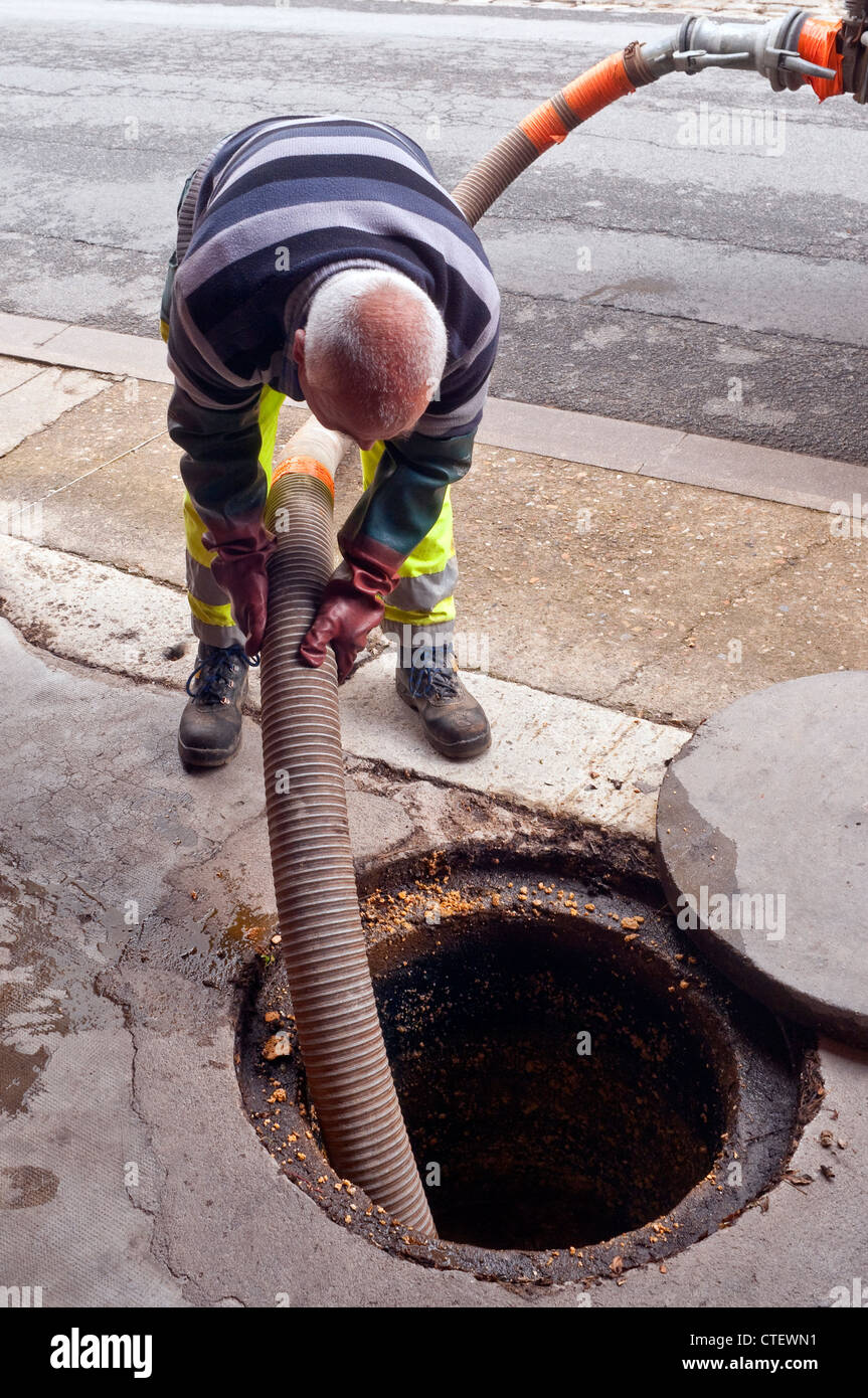 Worker with suction pipe in sewer manhole - France Stock Photo - Alamy
