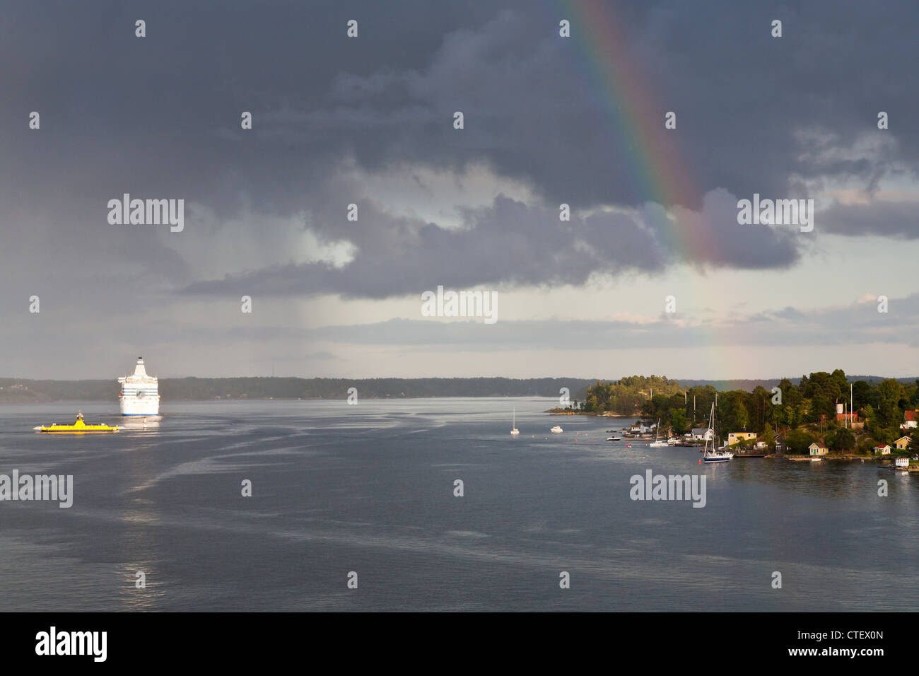 white cruise liner and rainbow in rain during sunshine in Baltic sea ...