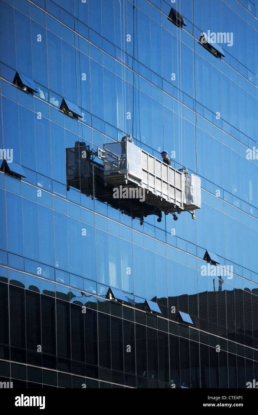 USA, New York, New York City, Manhattan, Window cleaners on scaffolding ...