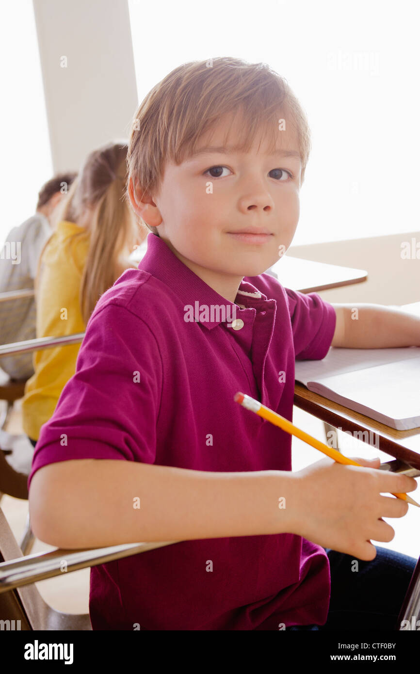 USA, California, Los Angeles, Schoolboy holding pencil in classroom ...