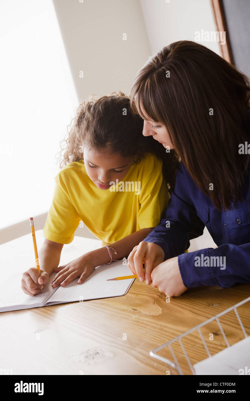 USA, California, Los Angeles, Schoolgirl writing with teacher in ...