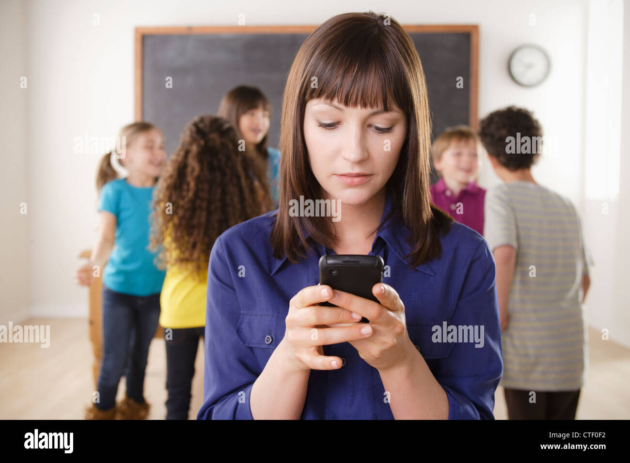 USA, California, Los Angeles, Teacher using mobile phone with group of ...