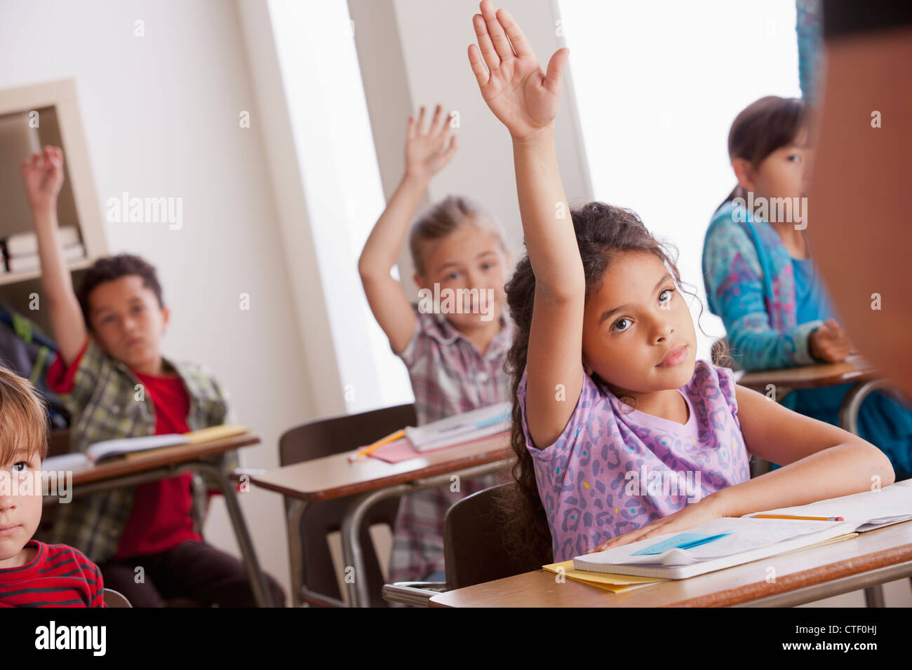 USA, California, Los Angeles, Pupils in classroom raising hands Stock ...