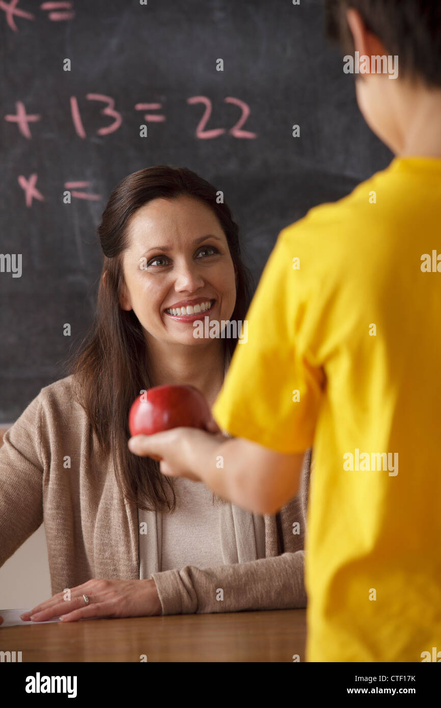 USA, California, Los Angeles, schoolboy (12-13) giving apple to his ...