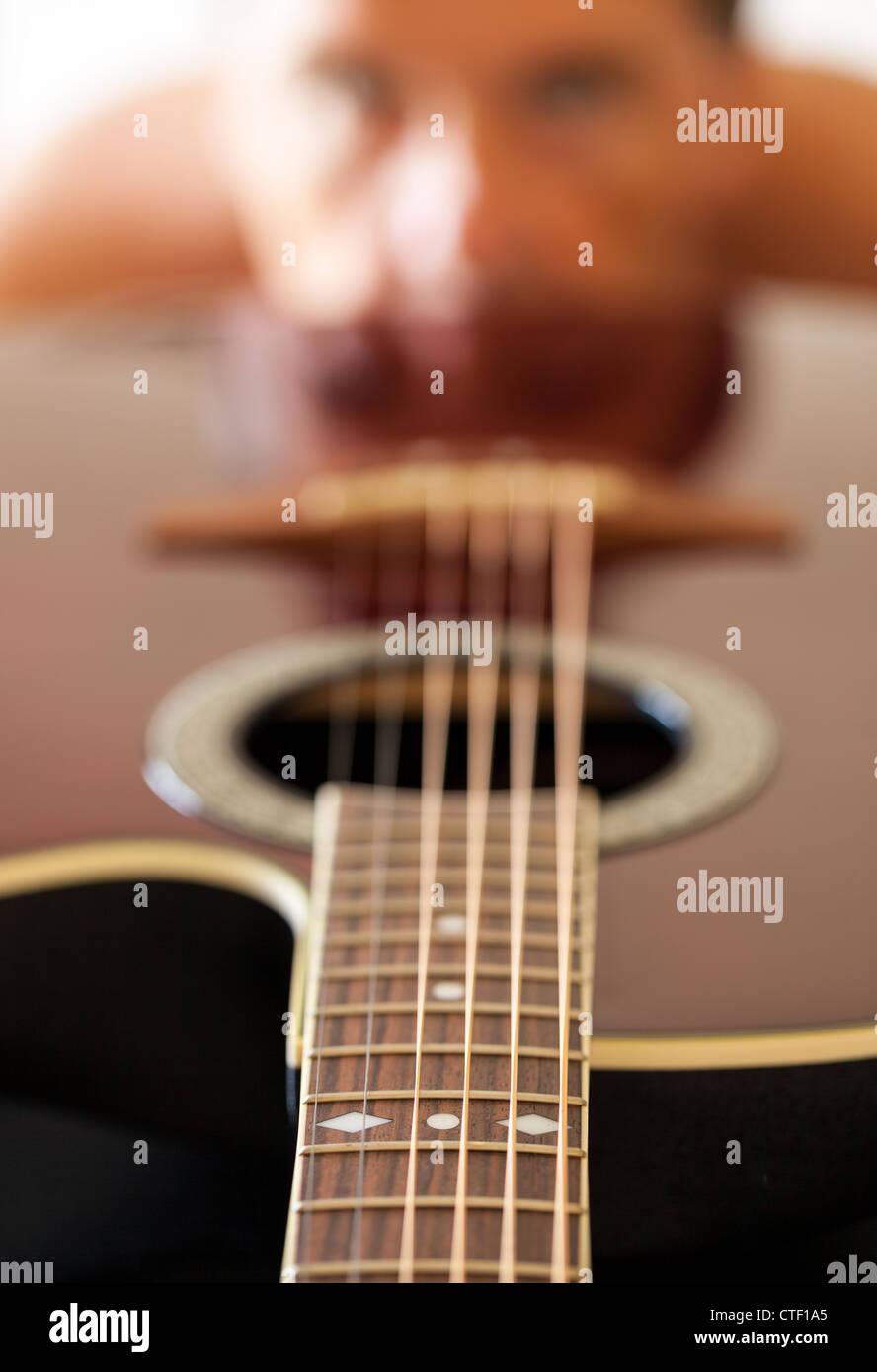 Macro shot down the fretboard of acoustic guitar with shallow depth of ...
