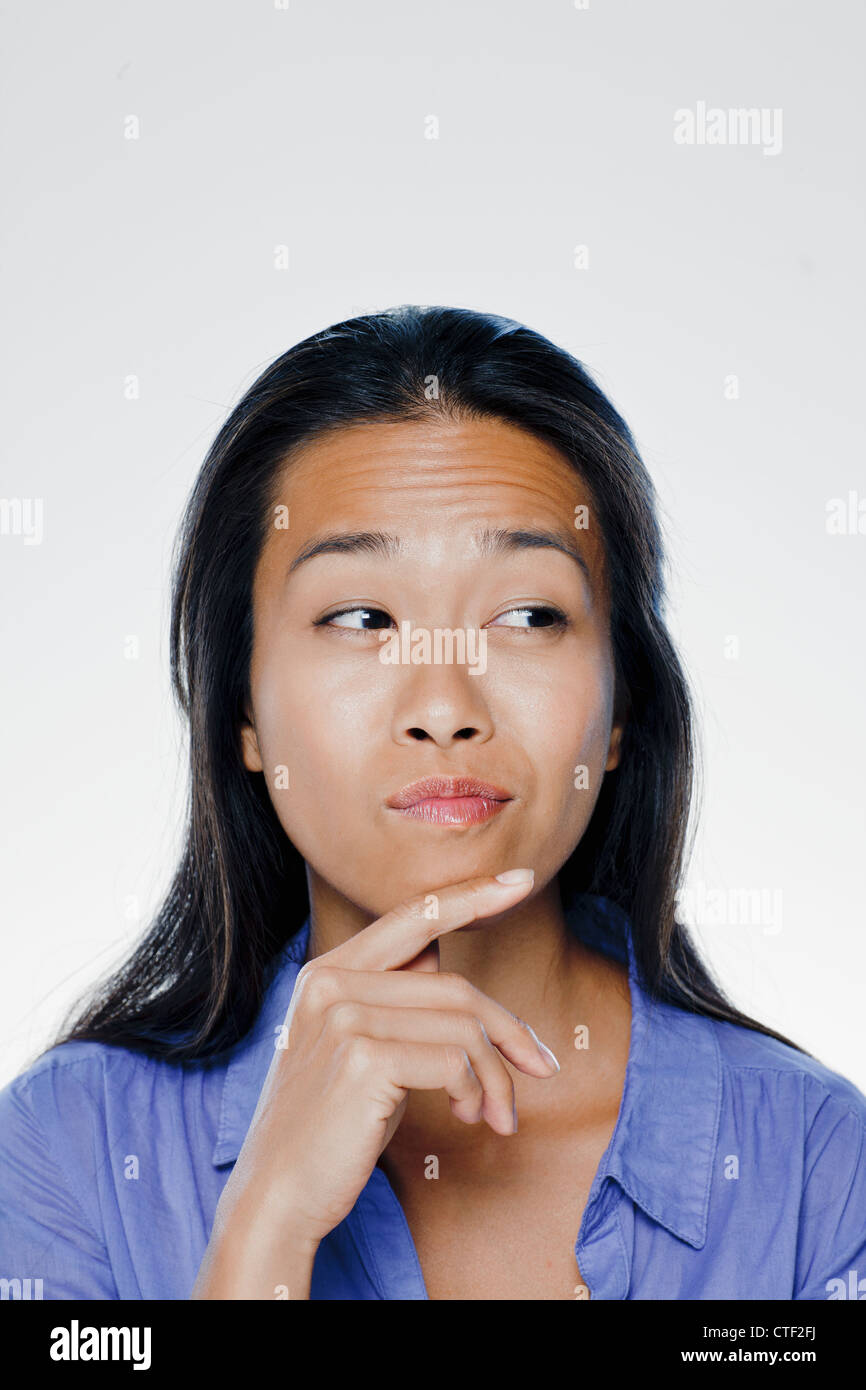 Portrait of confused young woman, studio shot Stock Photo - Alamy