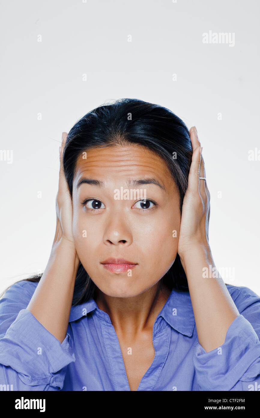 Portrait of young woman with hands covering ears, studio shot Stock ...