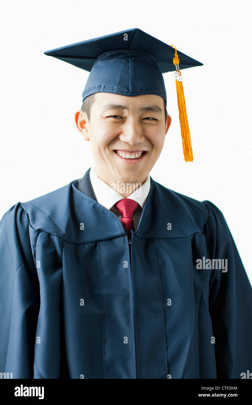 Portrait of young man in graduation gown, studio shot Stock Photo - Alamy