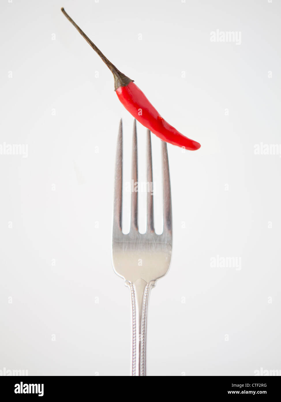 Chilli pepper on fork, studio shot Stock Photo - Alamy