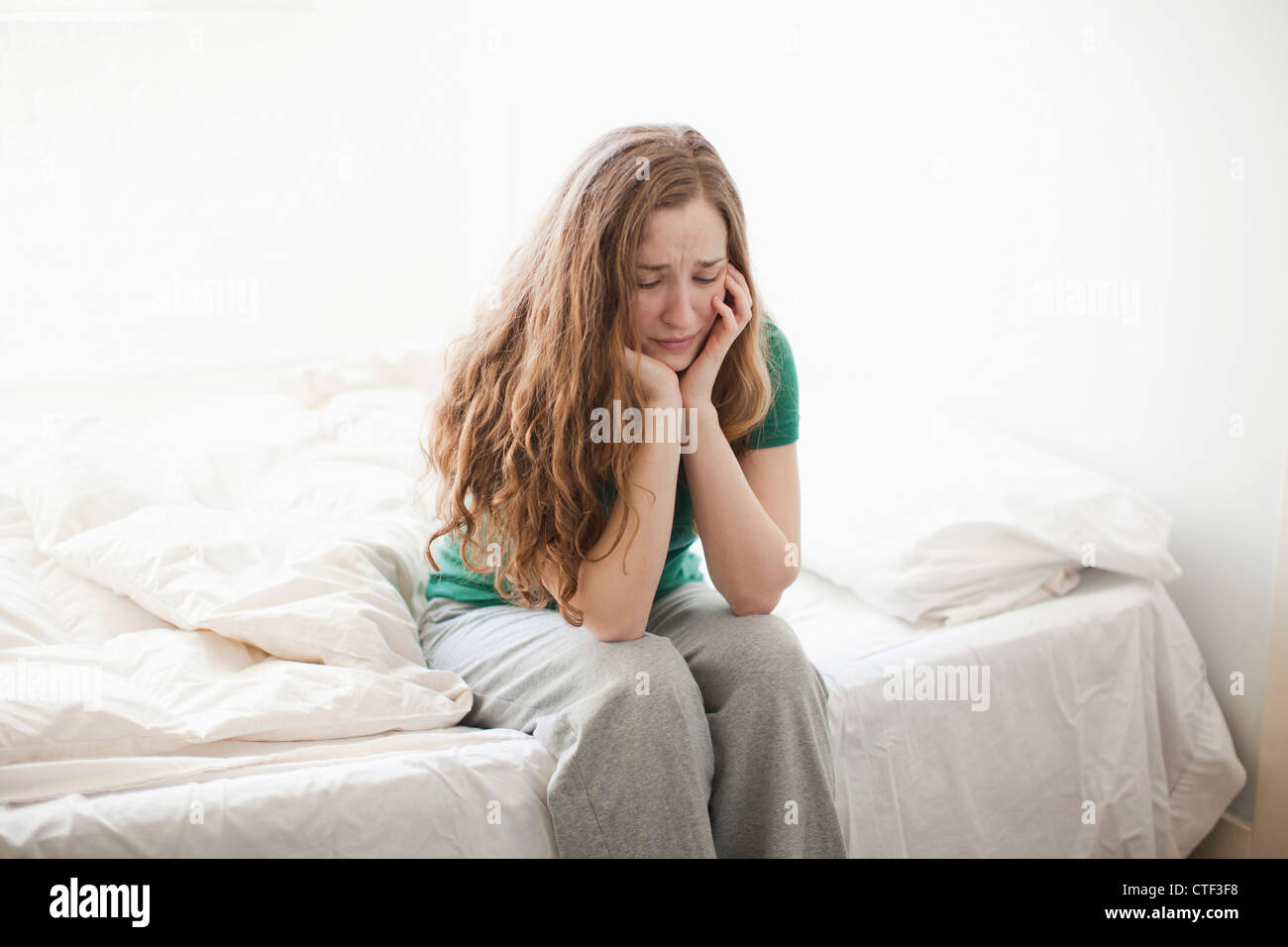 USA, Utah, Salt Lake City, Sad young woman sitting in bed Stock Photo ...