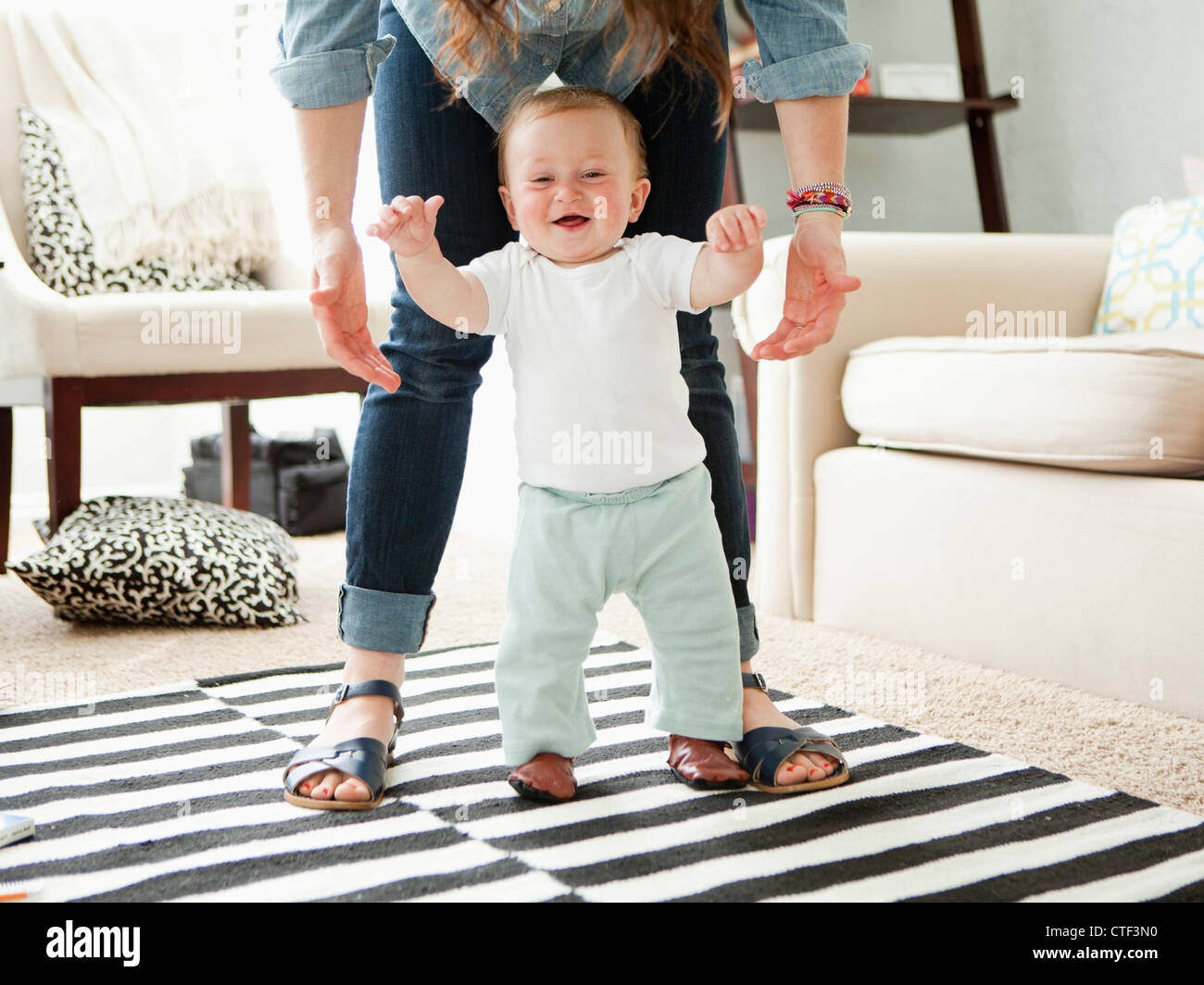 USA, Utah, Salt Lake City, Young mother assisting baby boy (6-11 months ...