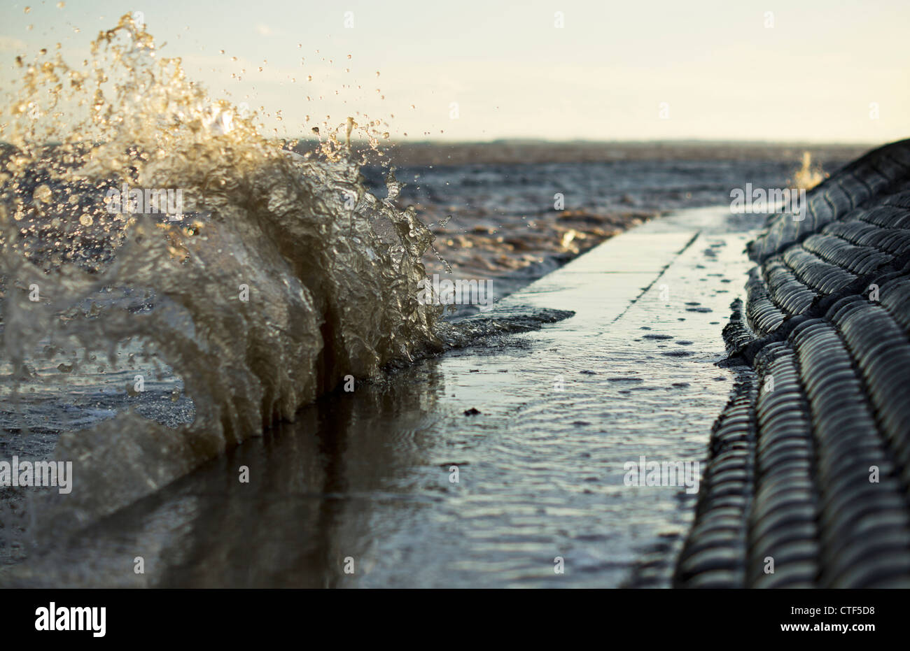 Waves breaking over sea wall Stock Photo - Alamy