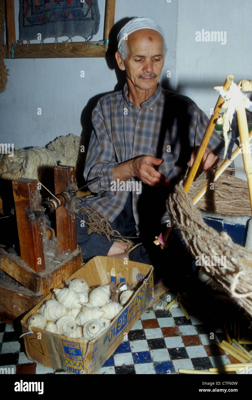 Muslim man spinning wool, Morocco. He has a sudja mark on his forehead ...