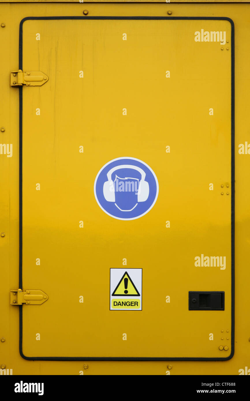 Ear defenders warning sign on yellow steel inspection panel Stock Photo ...