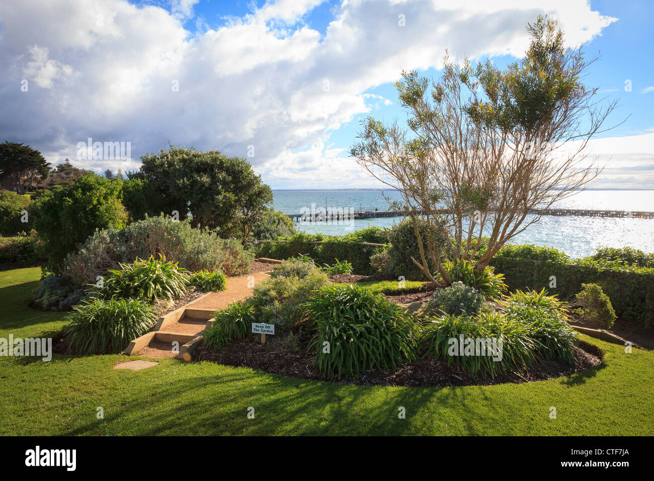 Australian sea side landscape with green garden and pier in the back ...