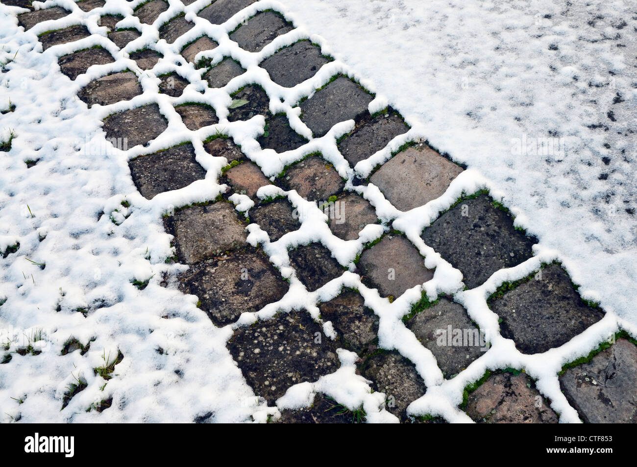 Snow on road revealing stone sets - France Stock Photo - Alamy