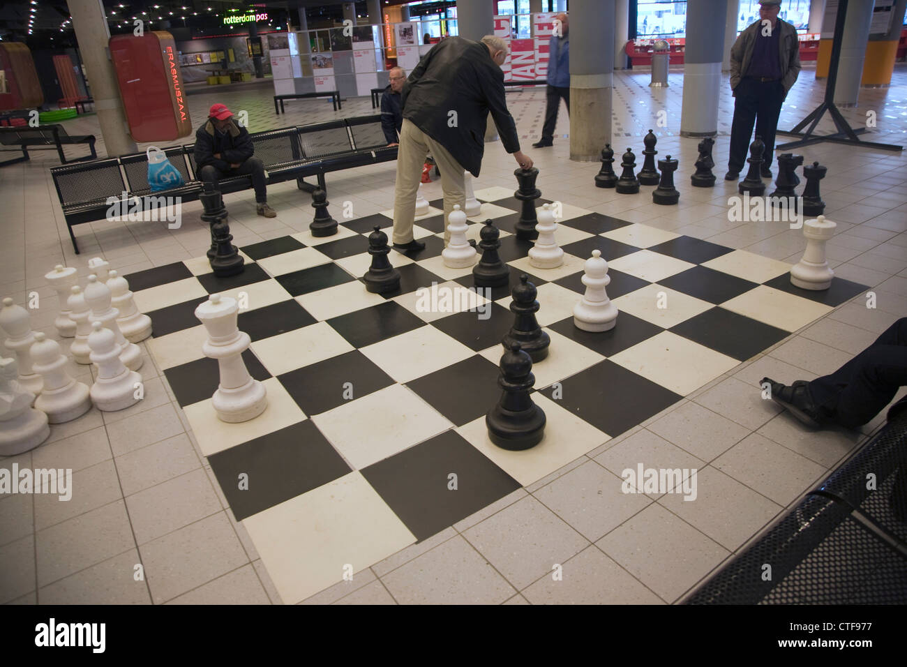 Men playing chess on large indoor chessboard inside the central public ...