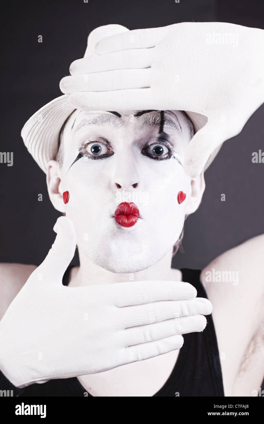 Portrait of a funny mime in white hat on a black background Stock Photo ...
