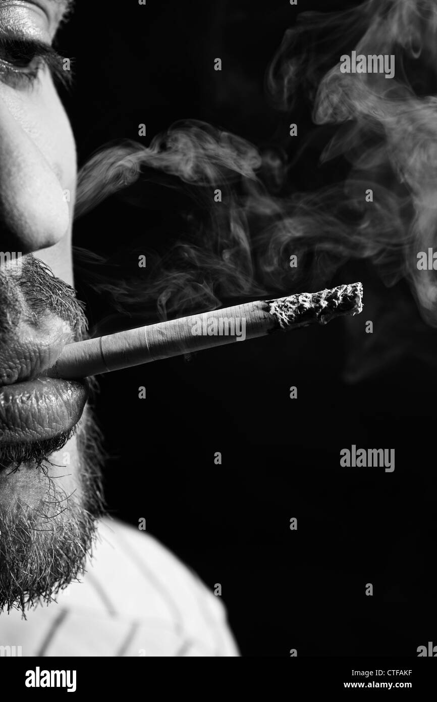 Face of a young man with a cigarette in his mouth Stock Photo - Alamy