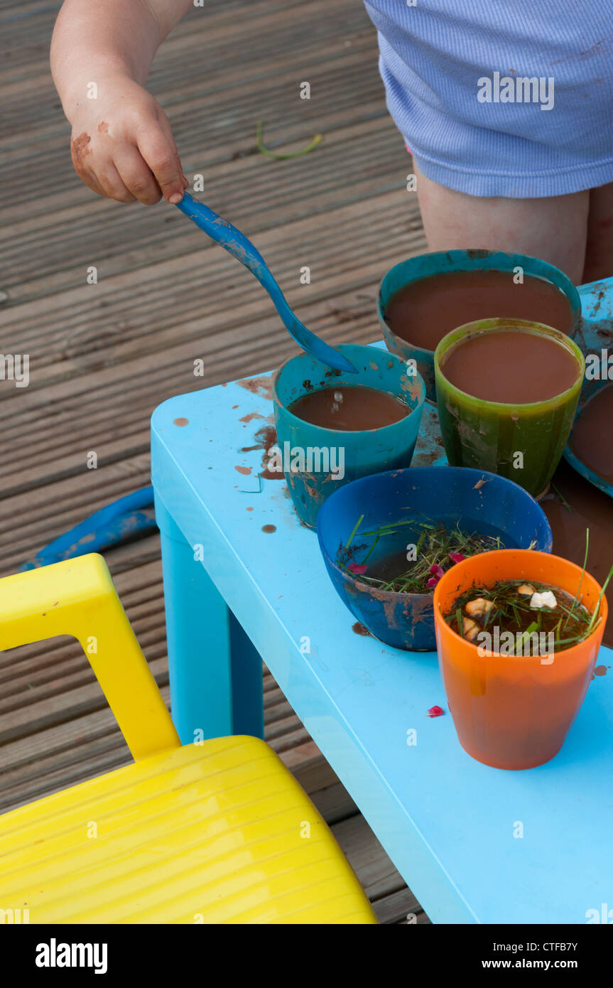 Young child playing outside with muddy water Stock Photo - Alamy