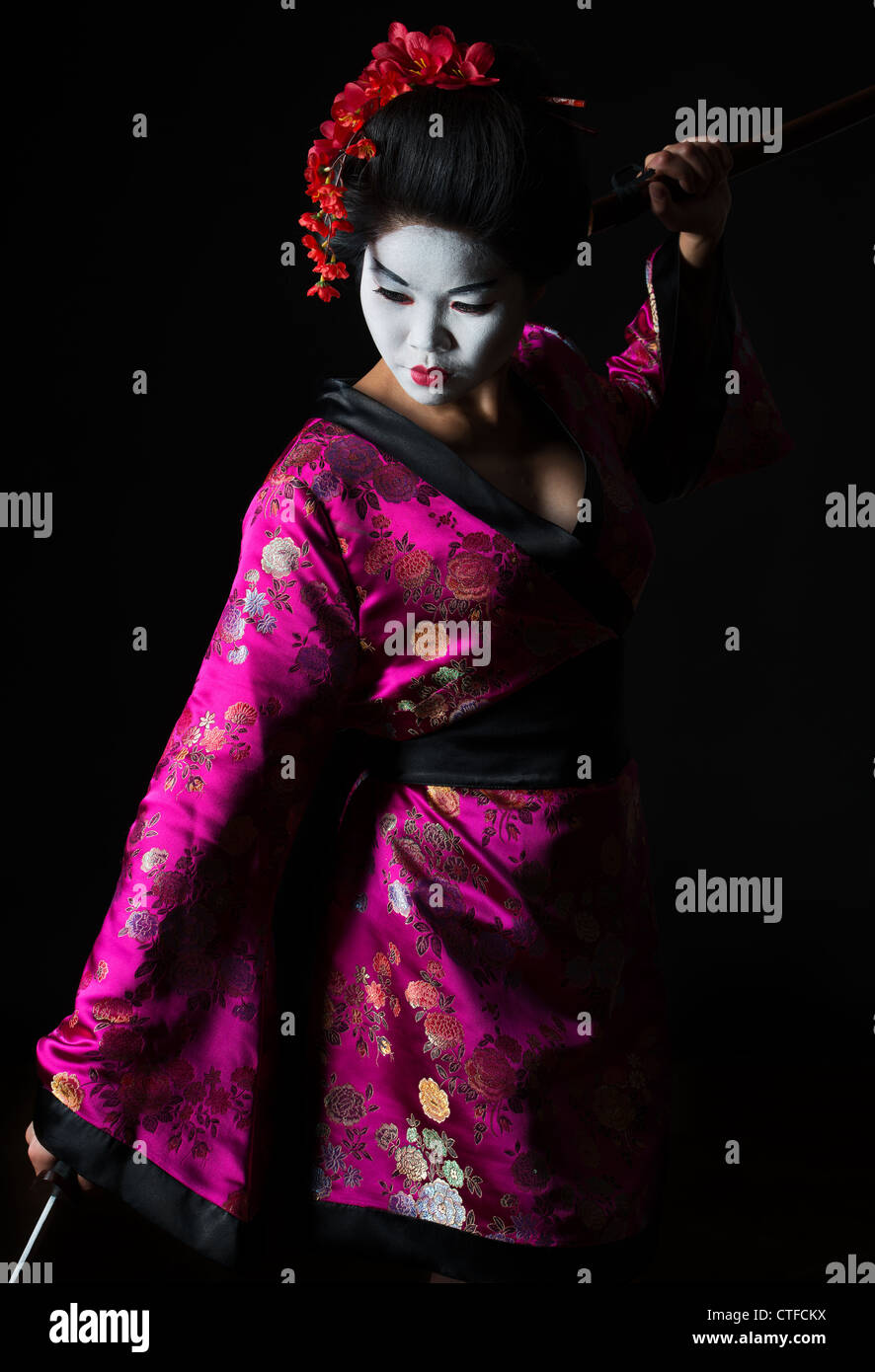 Portrait of geisha dancing with sword isolated on black Stock Photo - Alamy
