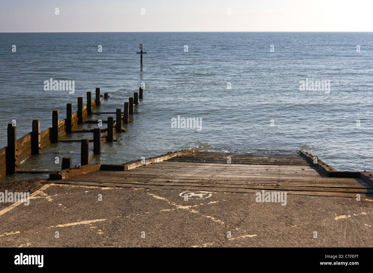 Slipway to the beach and sea at high tide at Walcott, Norfolk, England ...