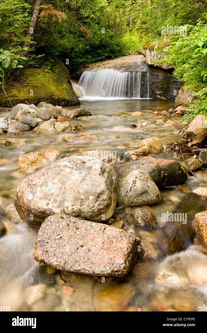 A small waterfall and a cascading creek through stones of granite Stock ...