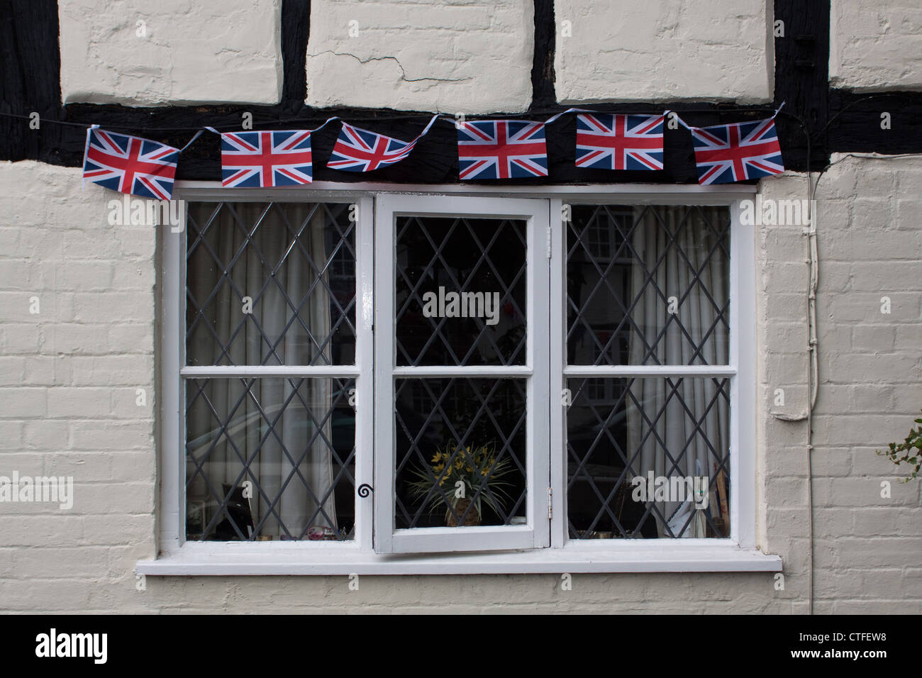 A row of union jack flag bunting above a window at a house in Wendover ...