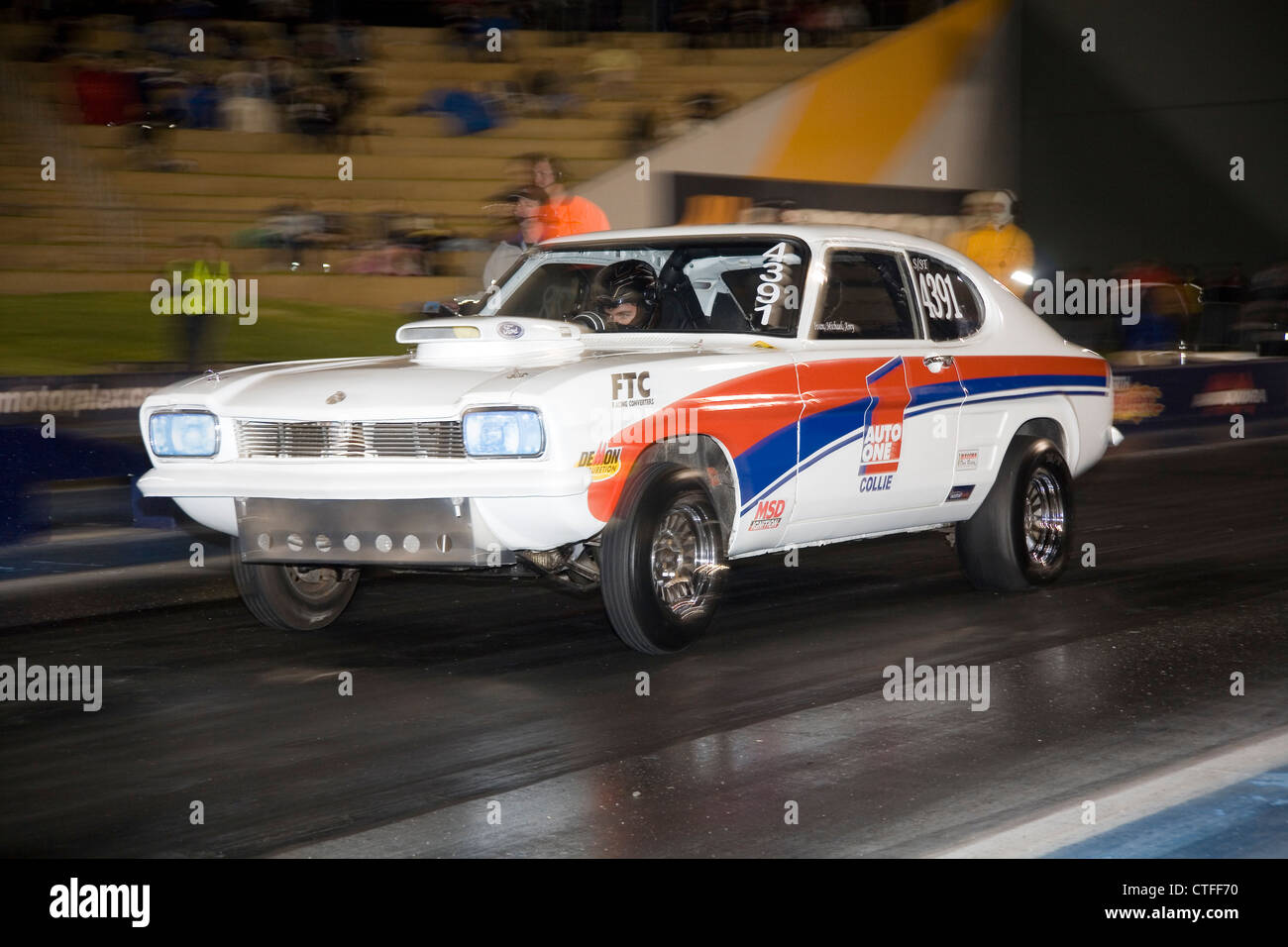 Modified and customized Ford Capri drag racing at a night race meeting ...