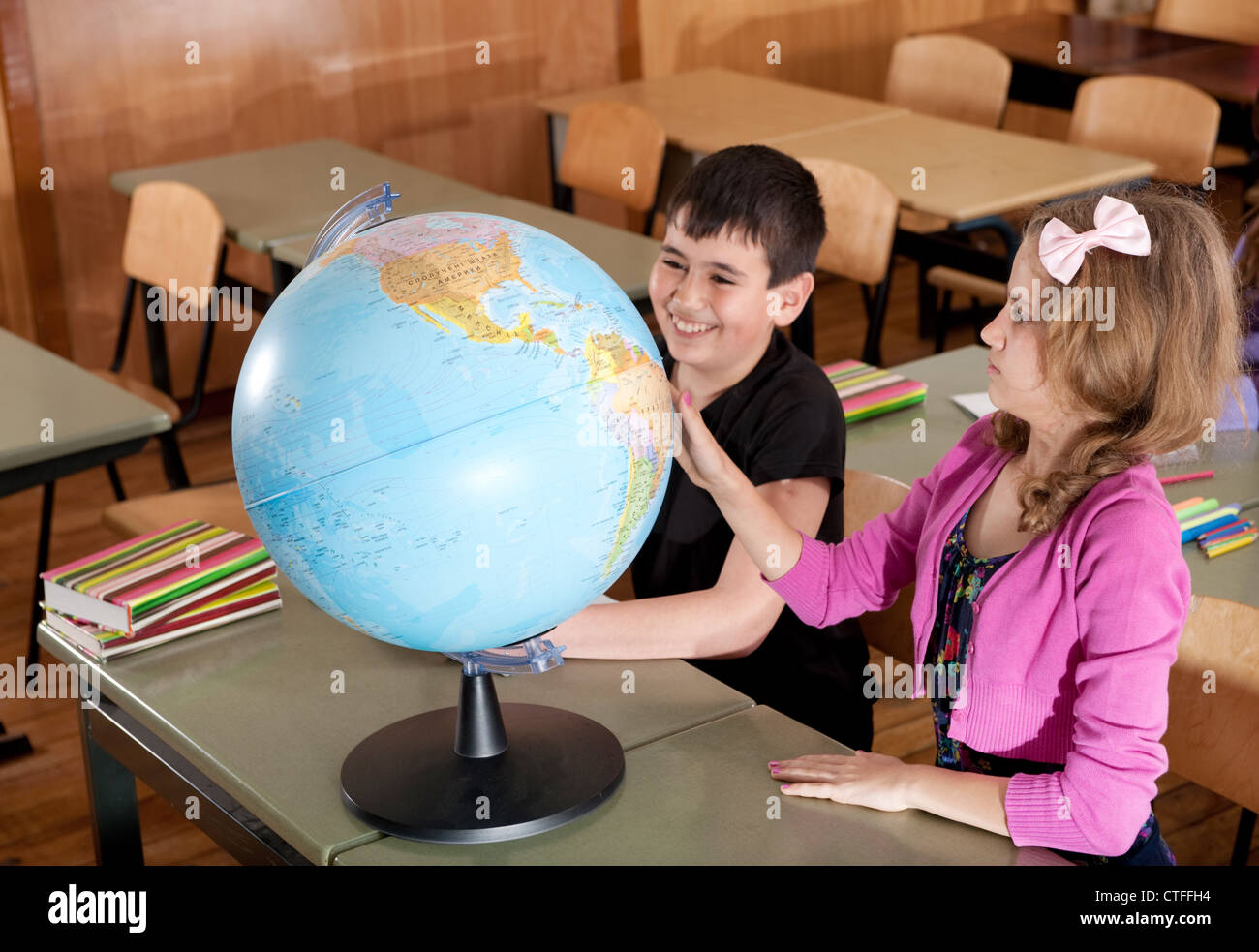 Schoolchildren are exploring globe in classroom during lesson Stock ...
