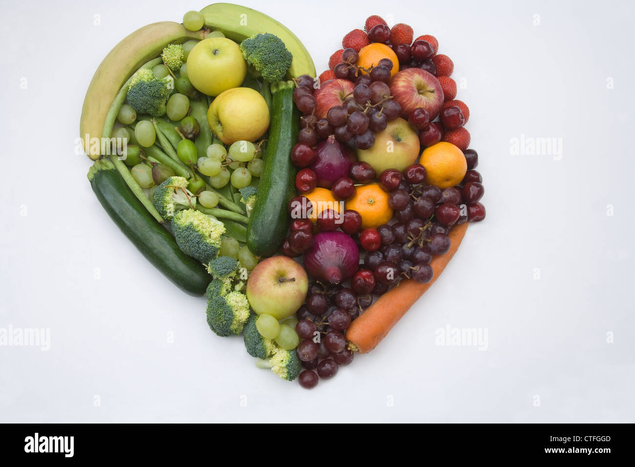 Studio Depiction of healthy heart with green and red fruit and ...