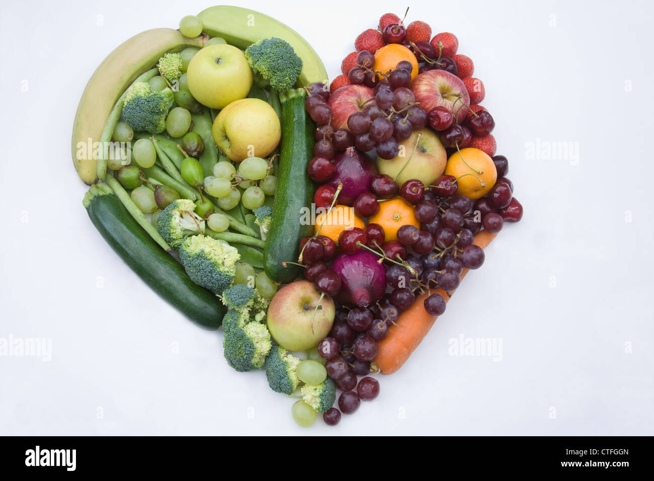 Studio Depiction of healthy heart with green and red fruit and ...