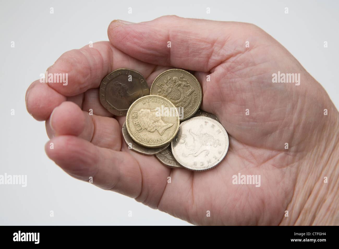 Studio Elderly woman's hand holding loose change money Stock Photo - Alamy