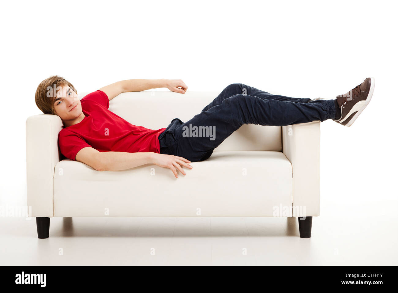 Handsome young man at home lying on the couch Stock Photo - Alamy