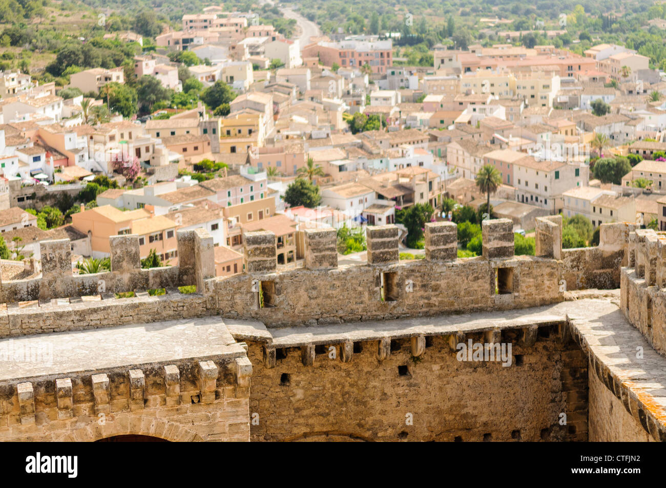 Fortified walls and ramparts at Capdepera Castle with the village down ...