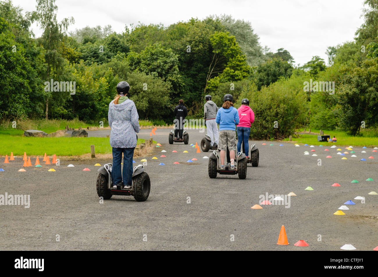 People riding Segway personal transportation around an obstacle course ...