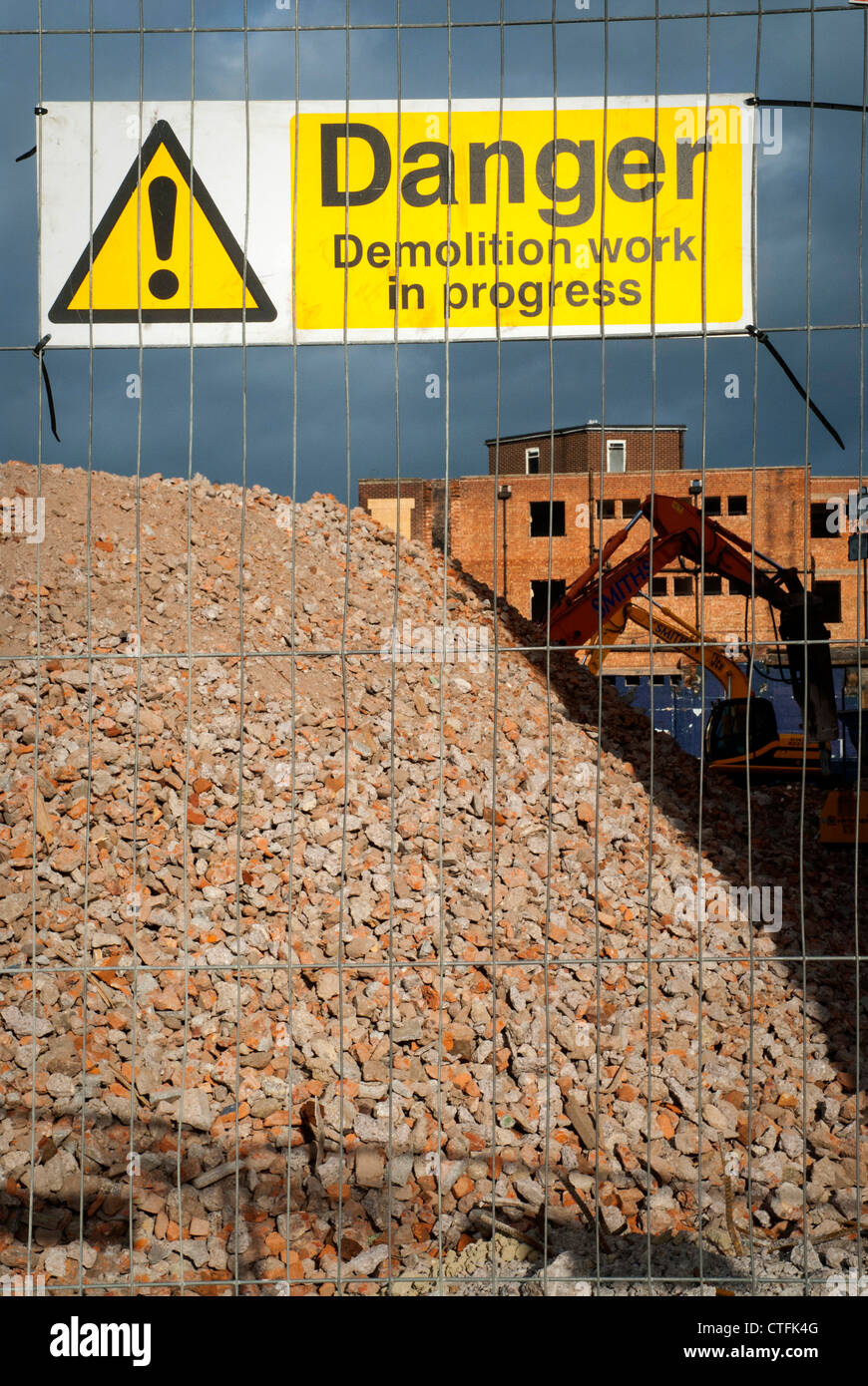 Danger sign and rubble from building demolition, refurbishment and ...