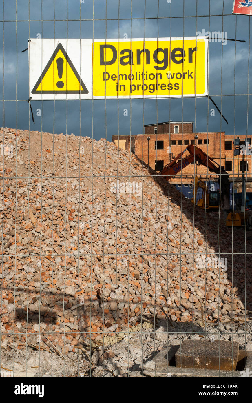 Danger sign and rubble from building demolition, refurbishment and ...