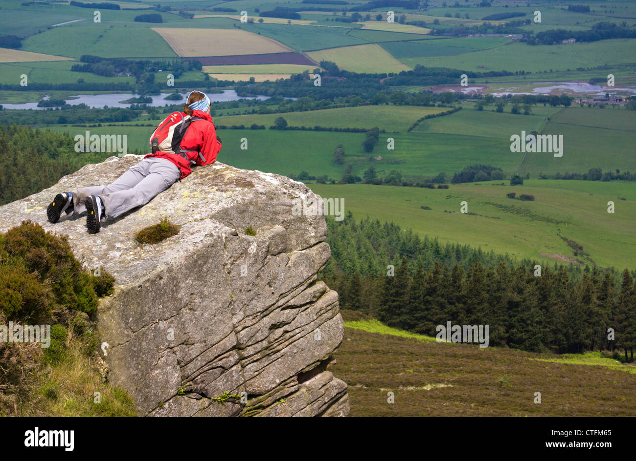 A hiker lying down taking in the views of the countryside from the top ...