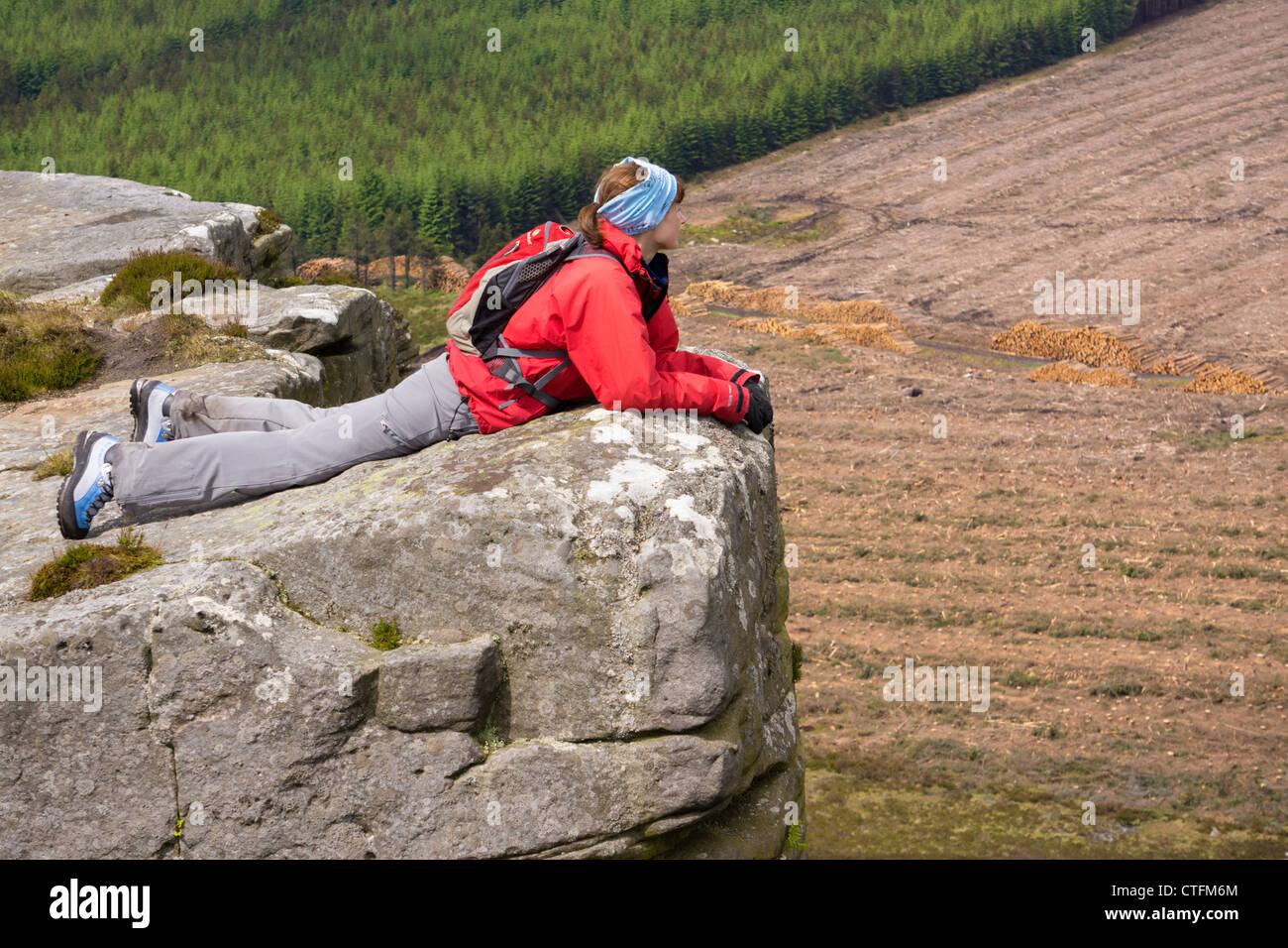A hiker lying down taking in the views of the countryside from the top ...