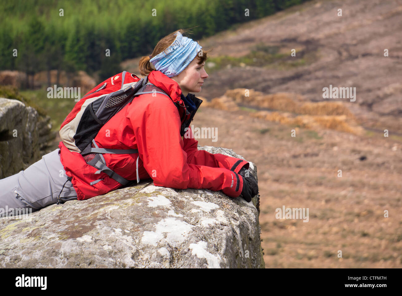 A hiker lying down taking in the views of the countryside from the top ...