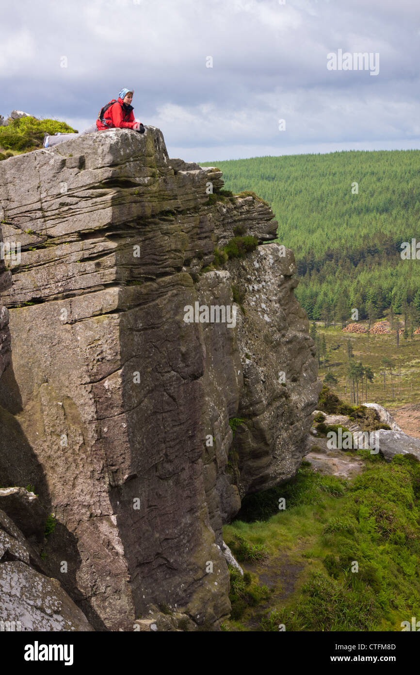 A hiker lying down taking in the views of the countryside from the top ...