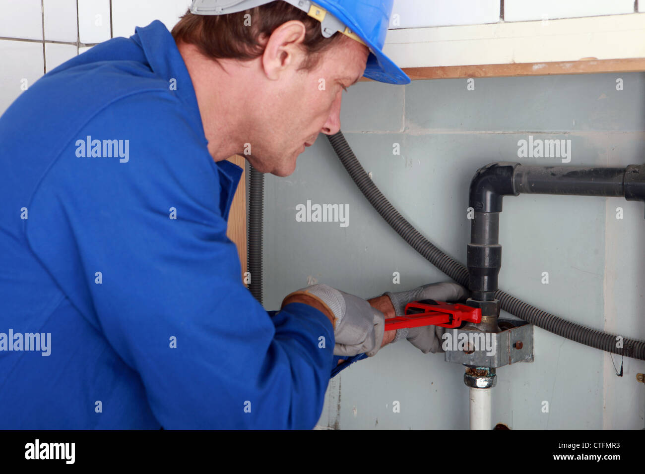 Plumber tightening a joint with a wrench Stock Photo - Alamy