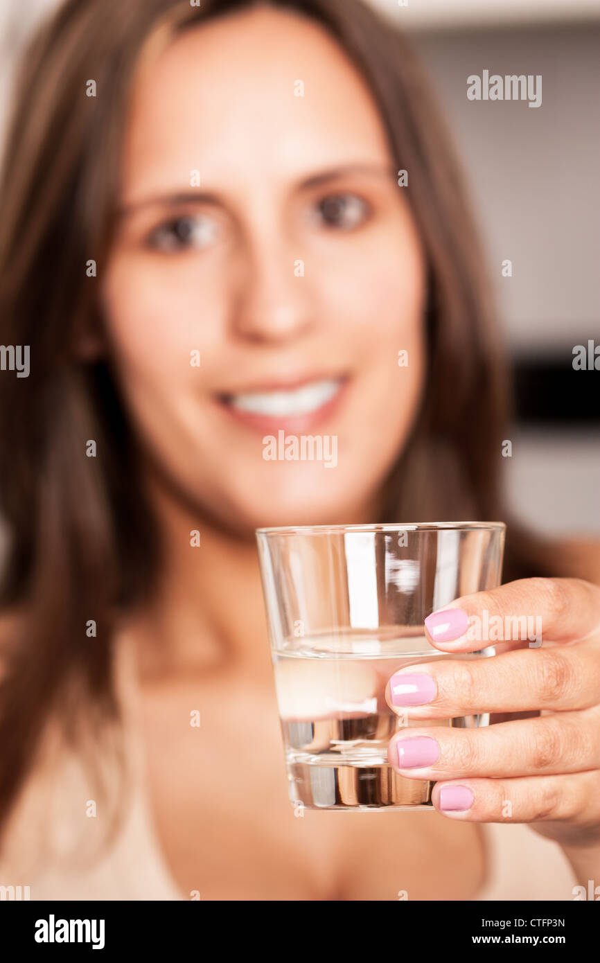 Woman holding a glass of water, she is out-of-focus Stock Photo - Alamy