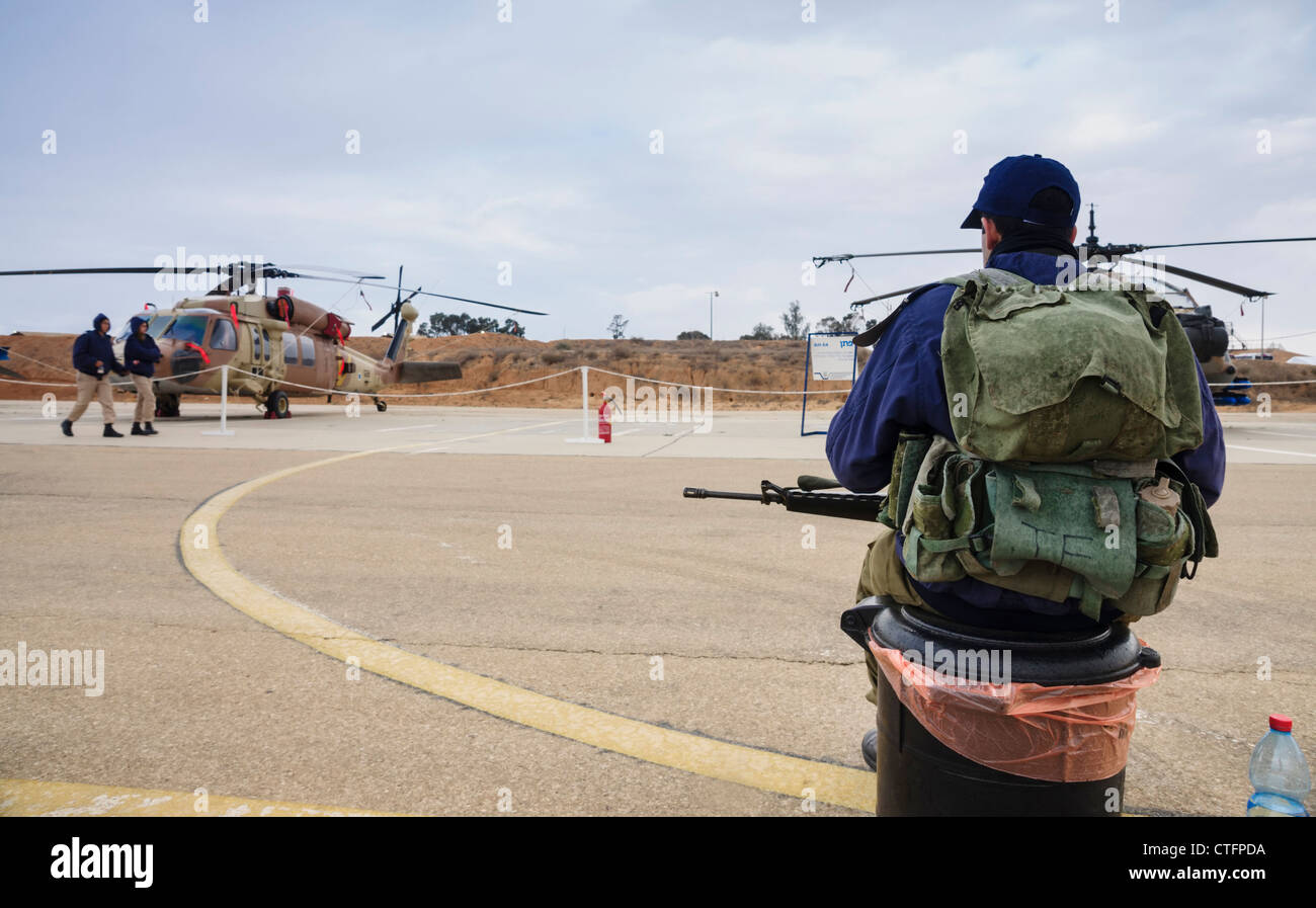 Israel. An IDF soldier, sitting on a trash can, guards an exhibition in ...