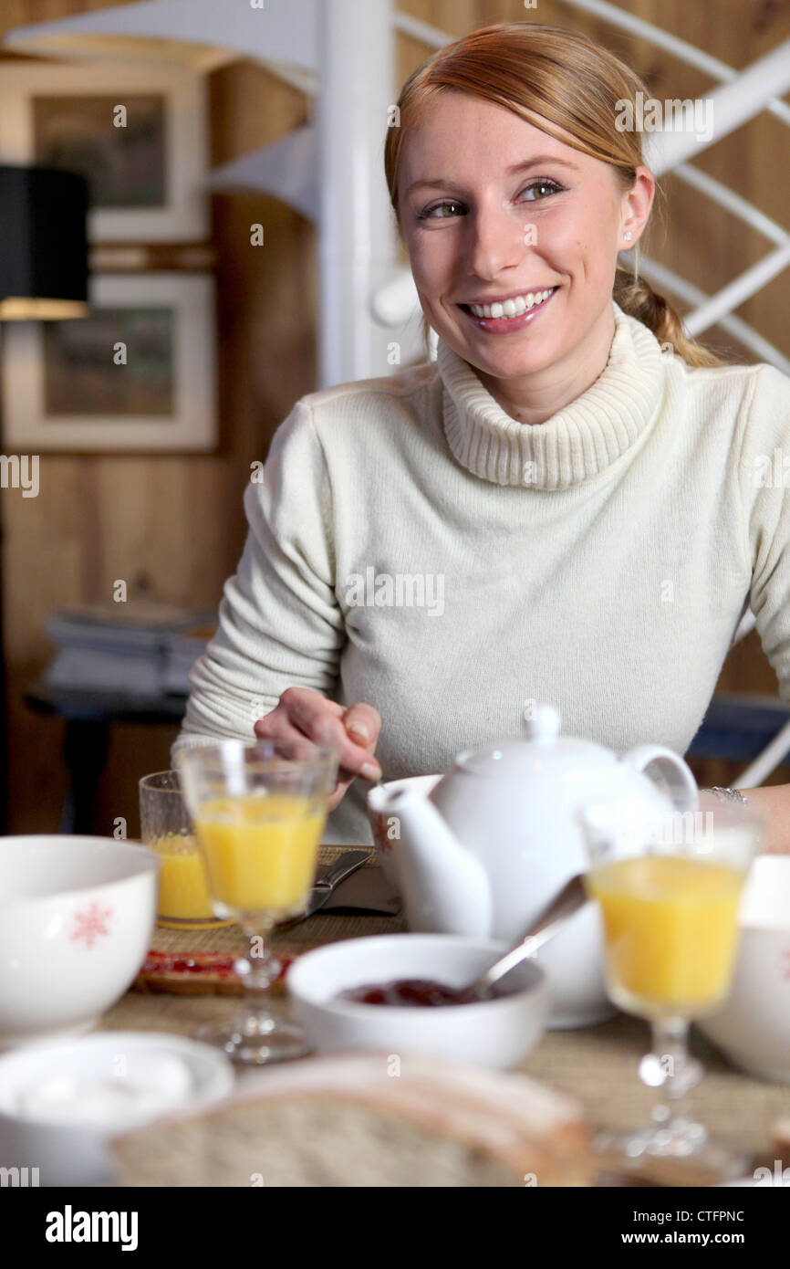 Woman eating breakfast at table Stock Photo - Alamy