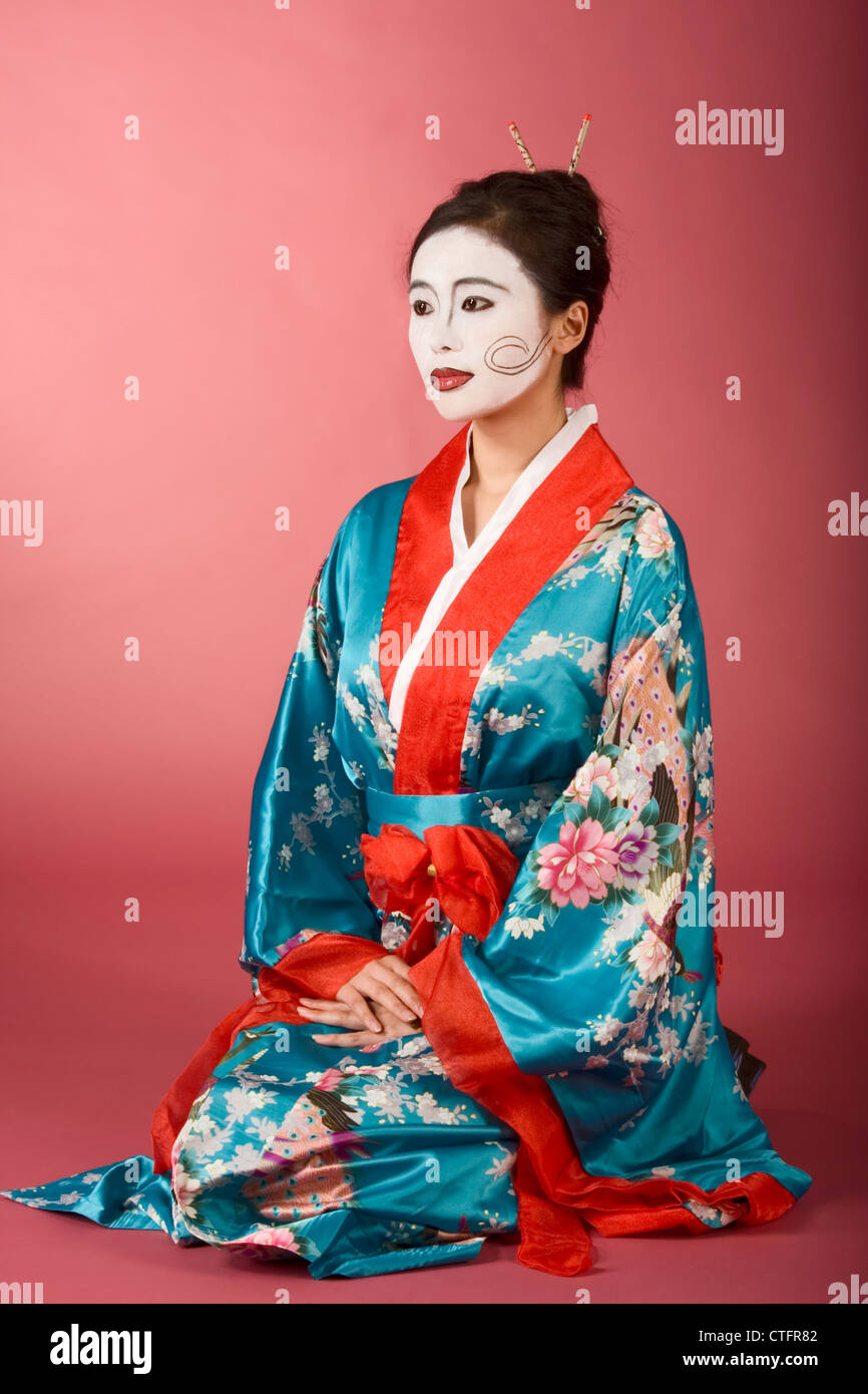 Asian female with geisha style face paint in yukata (kimono) sitting on ...